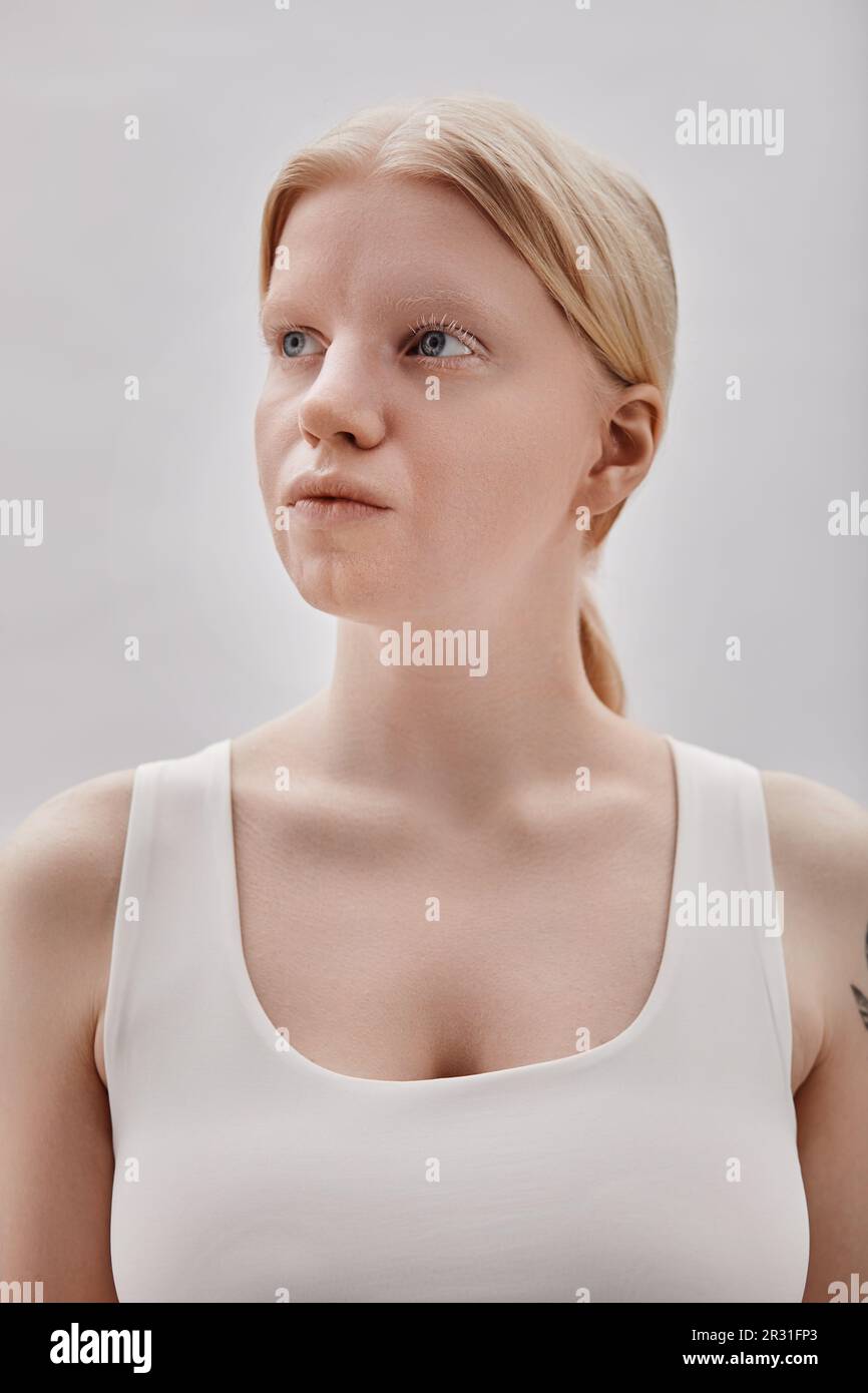 Minimal portrait of ethereal blonde girl with albinism posing against ...