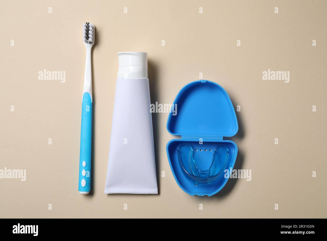 Toothpaste, brush and container with dental mouth guard on beige ...