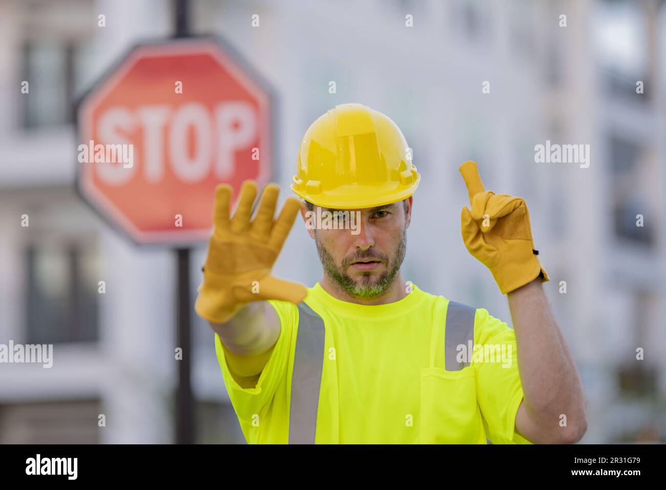 Serious engineer with stop road sign. Builder with stop gesture, no ...
