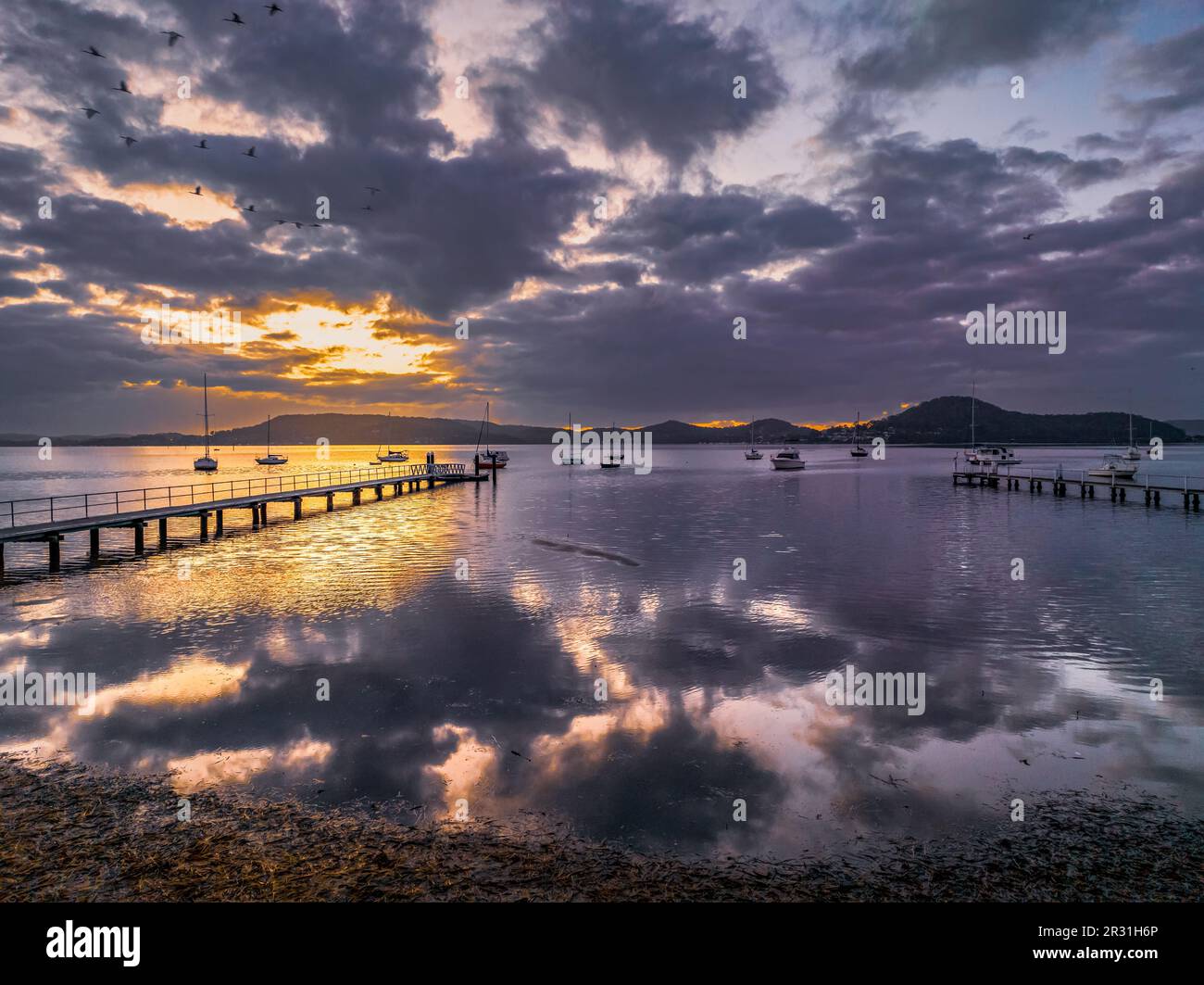 Sunrise bay waterscape with clouds and boats on the Brisbane Water at ...