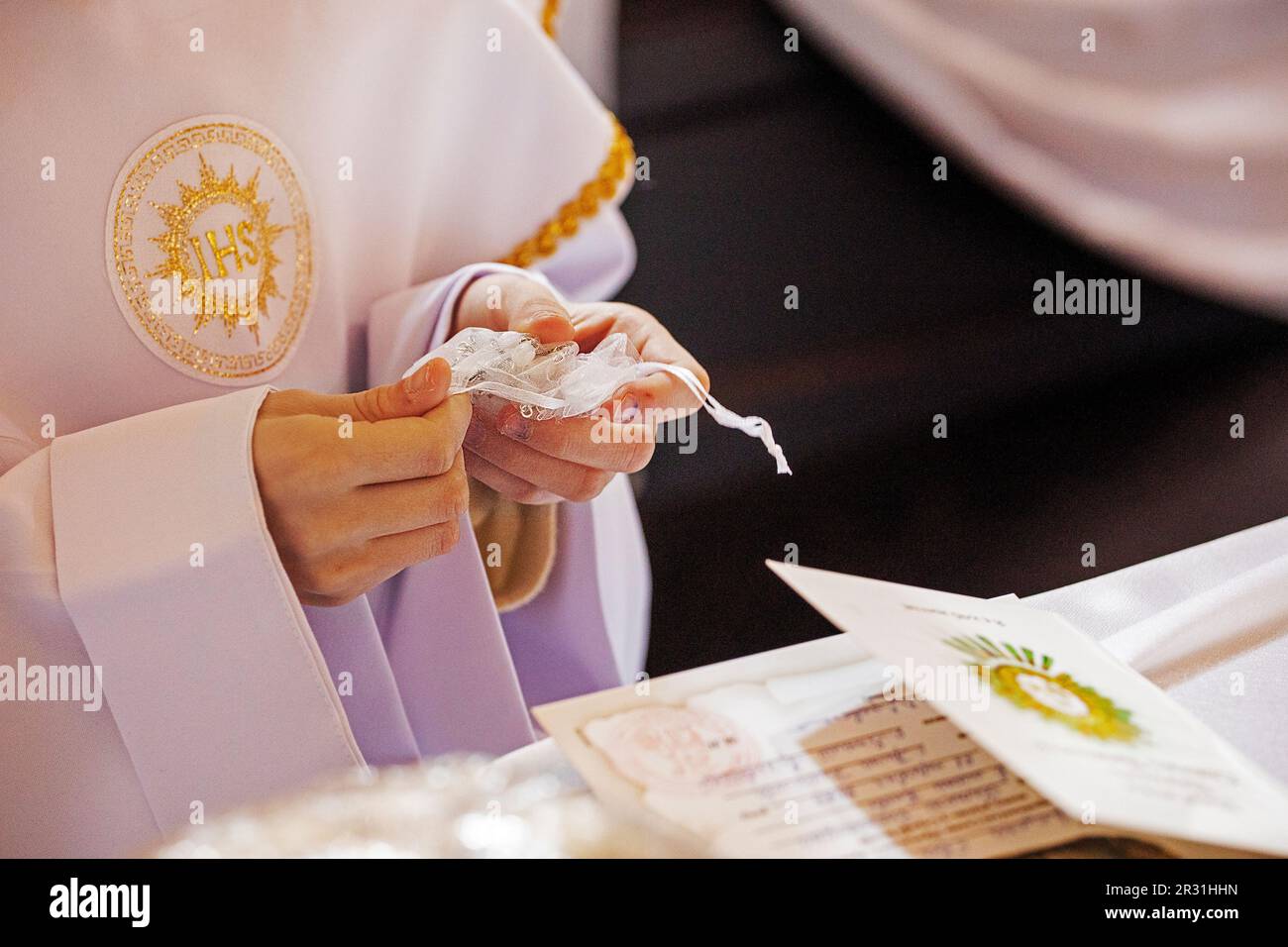 children's hands untie the bag, which contains the rosary for the first communion. Catahese ...