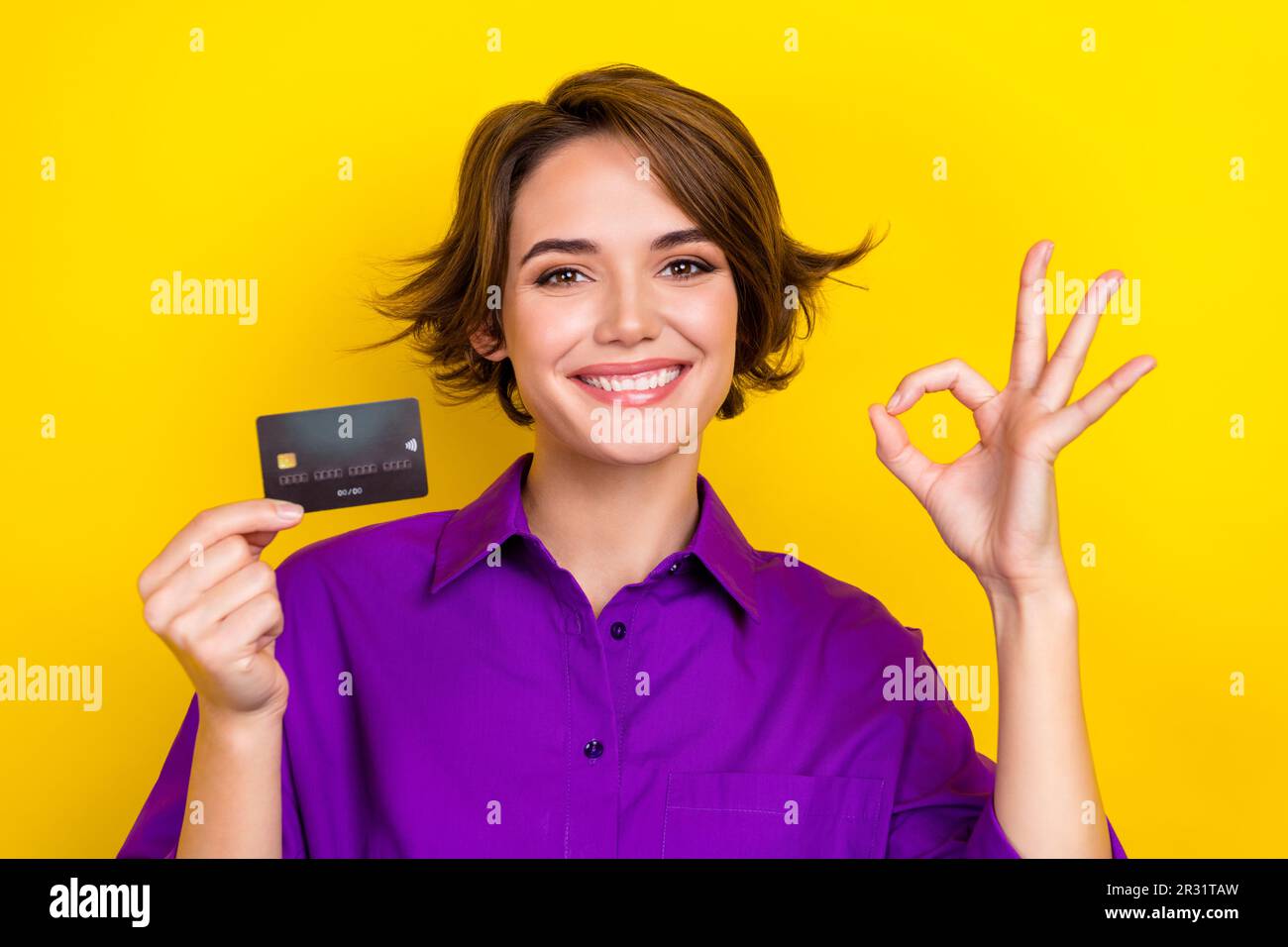 Photo of charming lady hold debit card show okey symbol wear purple ...