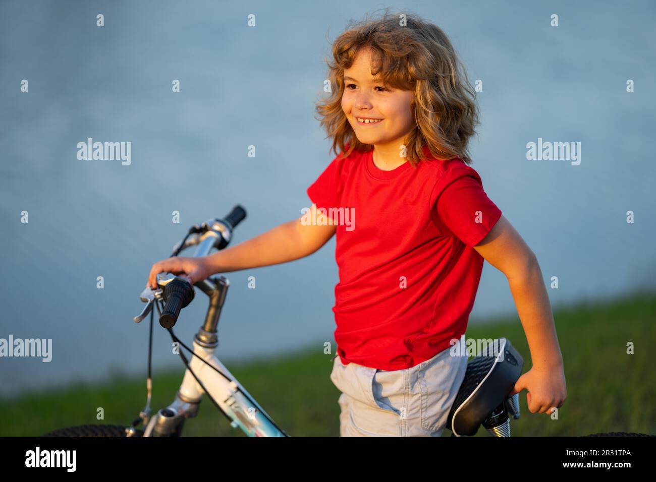 Happy kid boy riding bike in summer park Stock Photo - Alamy