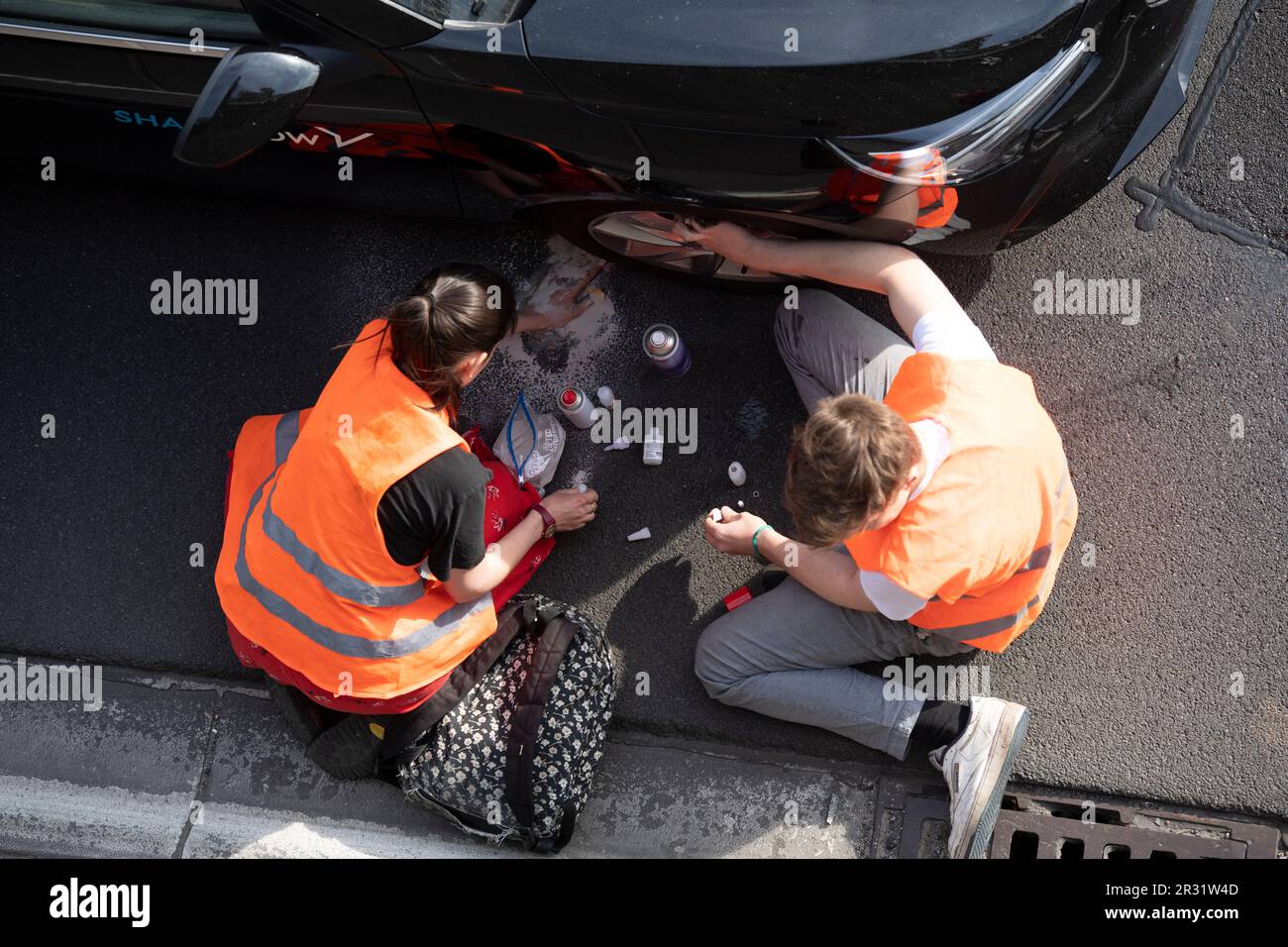 Berlin, Germany. 22nd May, 2023. Activists tape themselves to a car ...