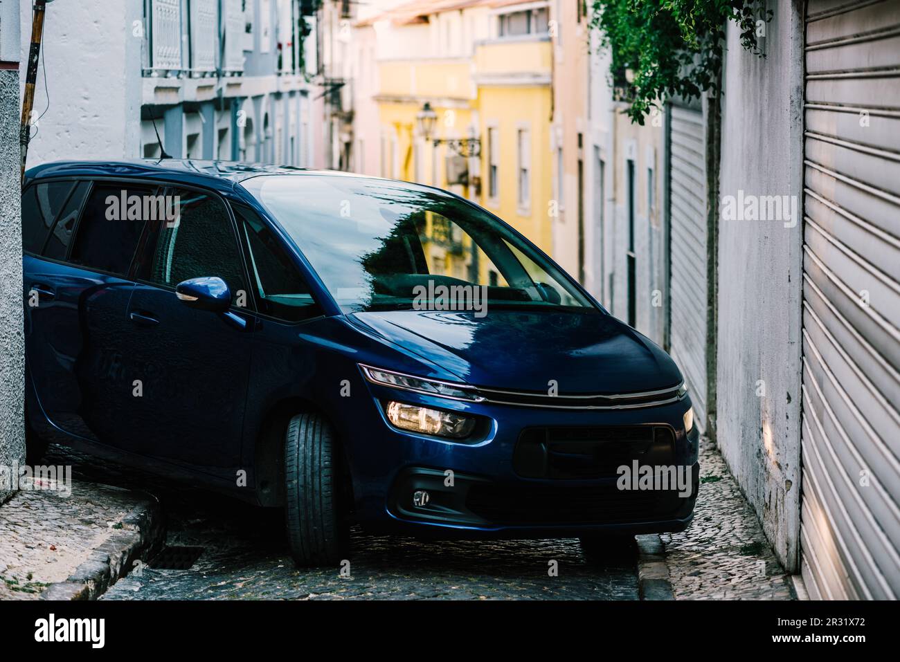 Large vehicle trying to turn a curve in a narrow street in Lisbon's ...