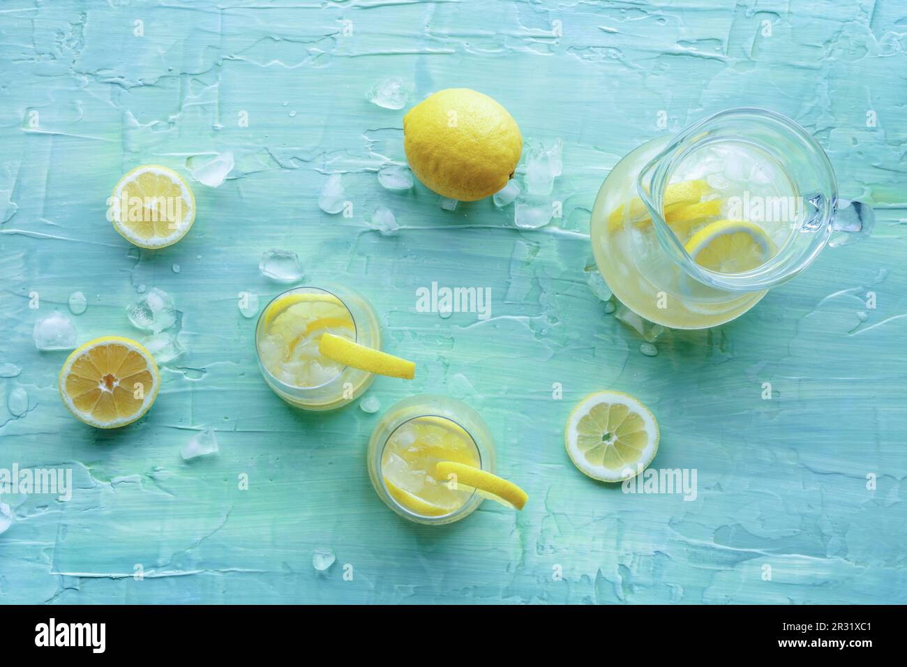 Lemonade. Lemon water drink with ice. Two glasses and a pitcher on a ...