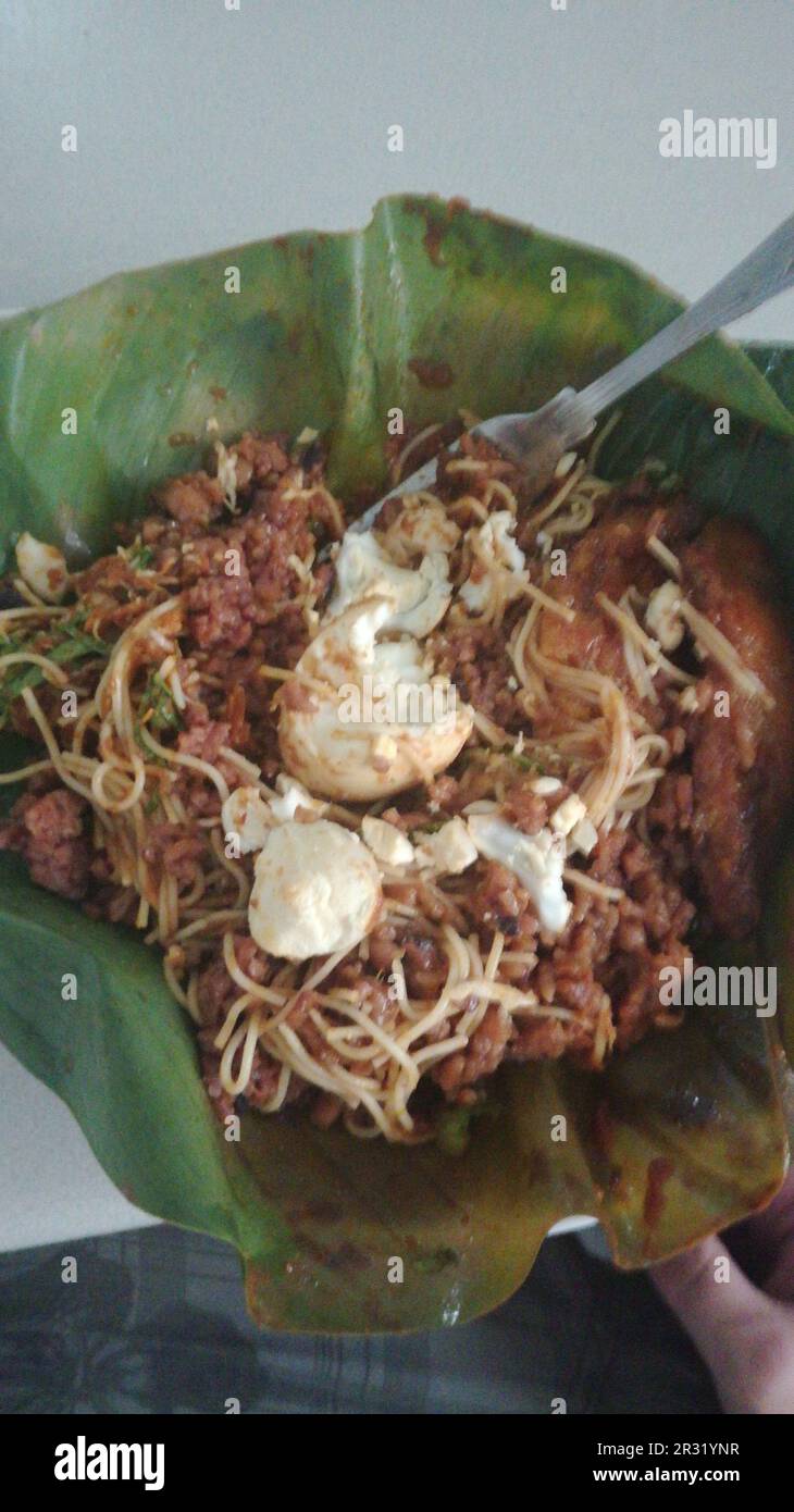 A close-up of Waakye a Ghanaian Dish wrapped in a leaf ready to eat ...