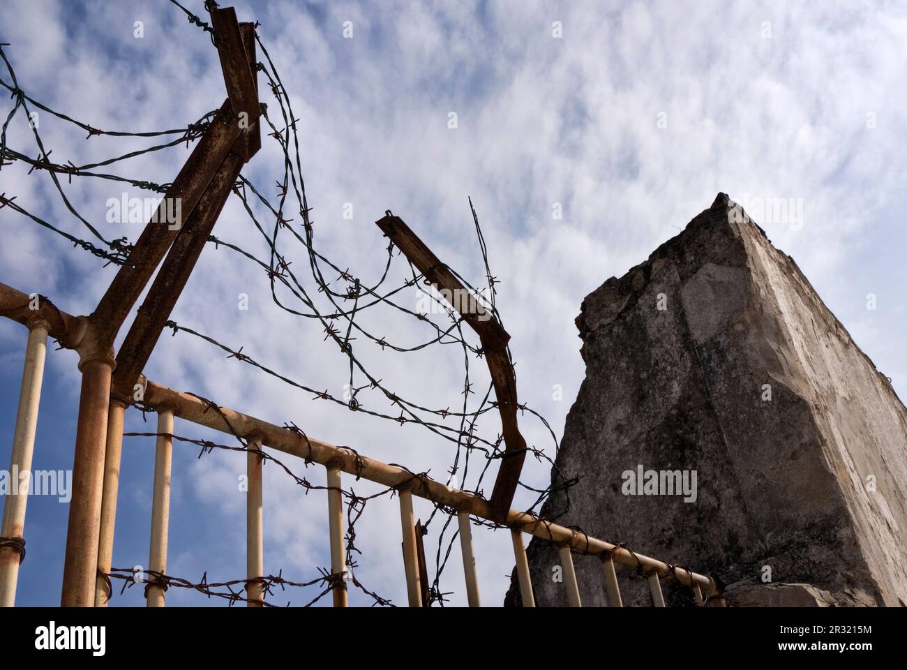Gate with barbed wire and wall Stock Photo - Alamy