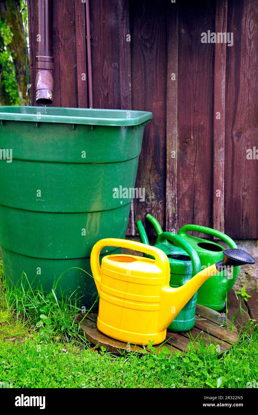 Rain barrel and watering cans Stock Photo - Alamy