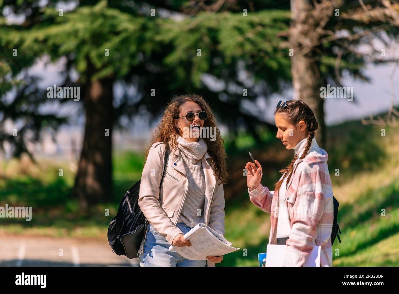 Brunette girl failed the school exam. Curly haired girl is joking with ...