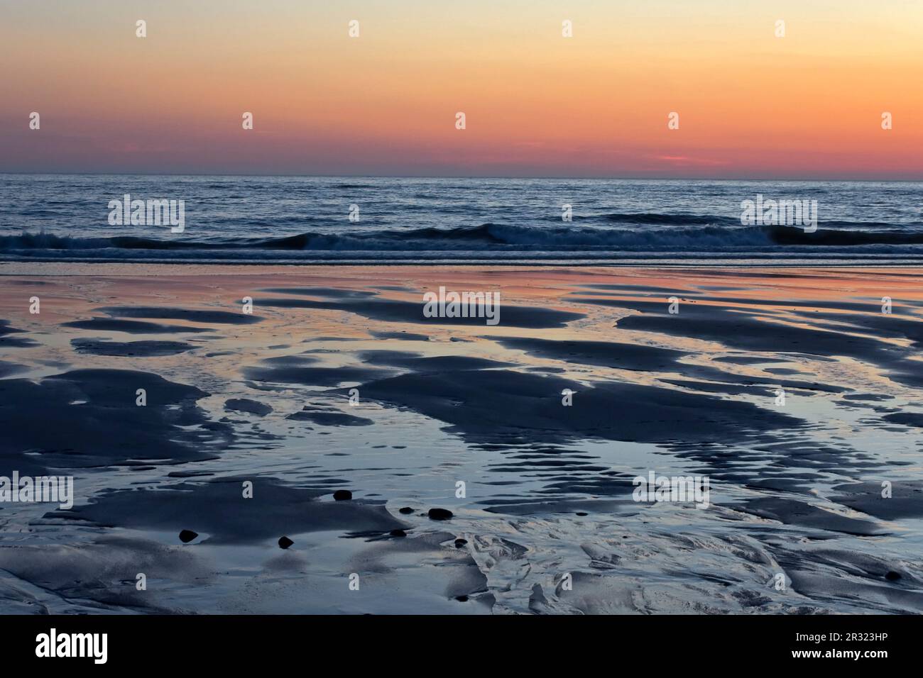 Sunset, reflection in mudflat Stock Photo - Alamy