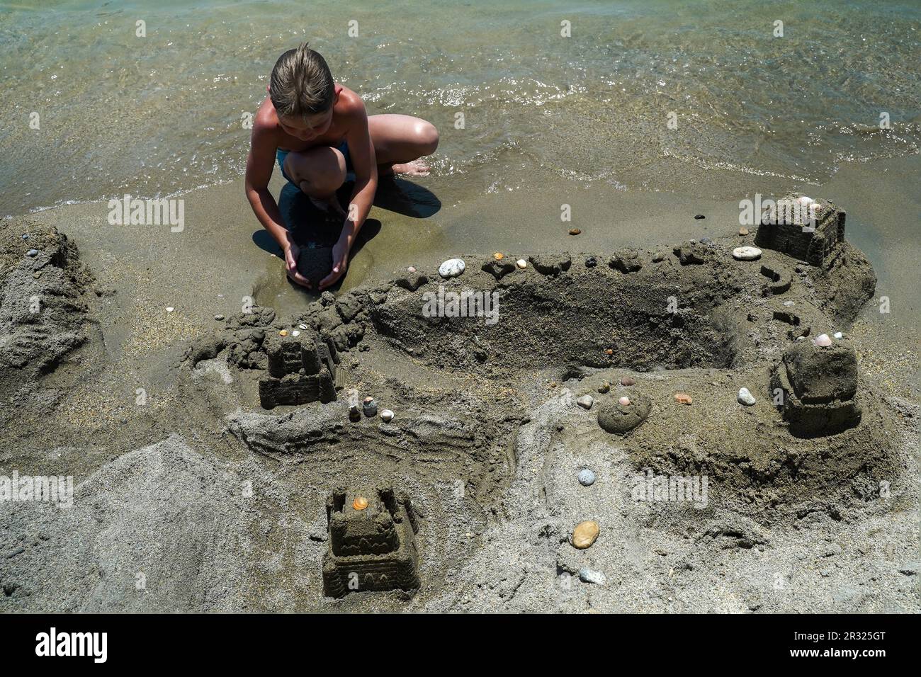 A child builds sand castles and city, top view. Sand City Stock Photo ...
