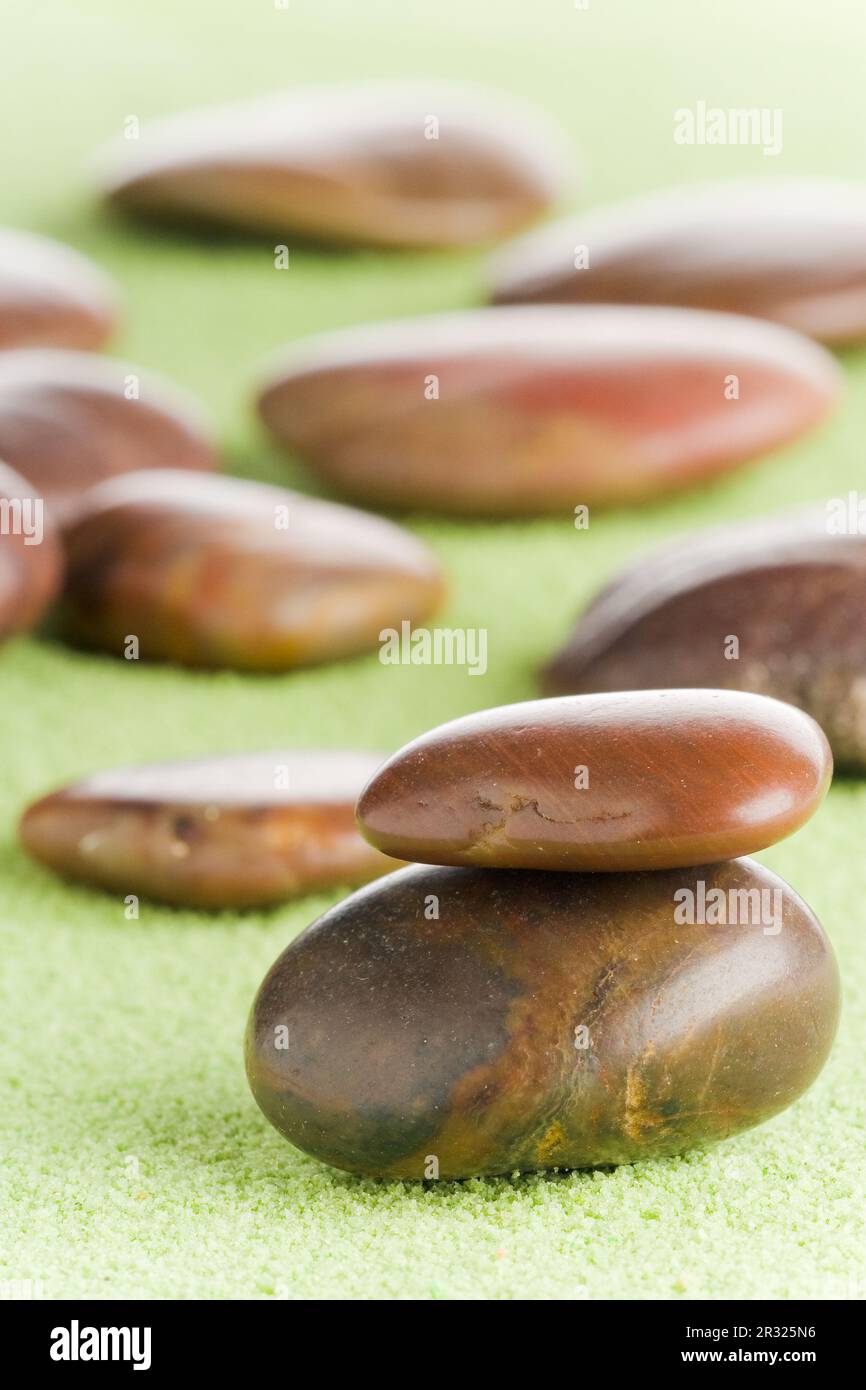 Stones on green sand Stock Photo - Alamy