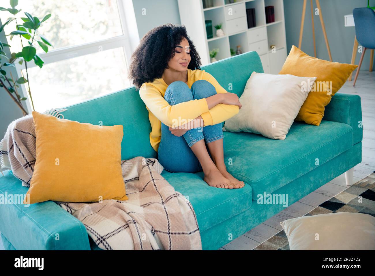 Full body portrait of satisfied lovely lady sitting sofa arms hug legs ...
