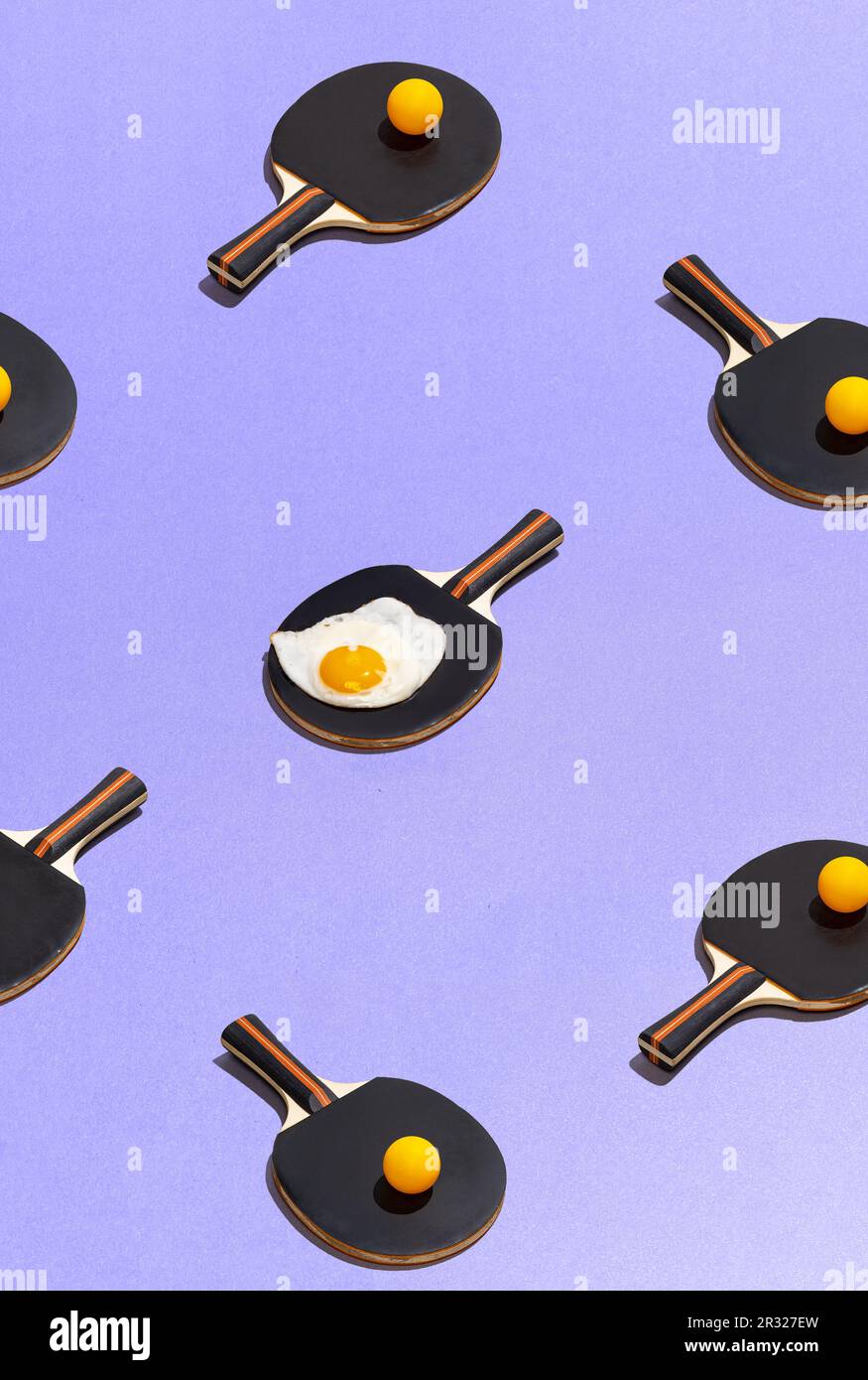 Food pattern with fried egg on table tennis racket on purple background ...