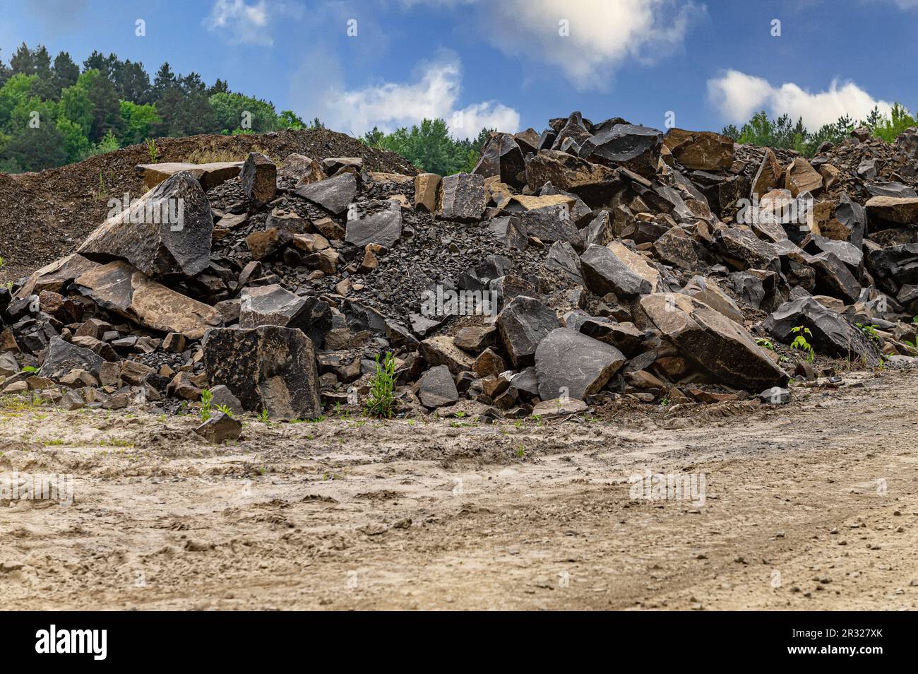 Basalt stones in a quarry. Columnar basalt quarry in summer. Volcanic ...