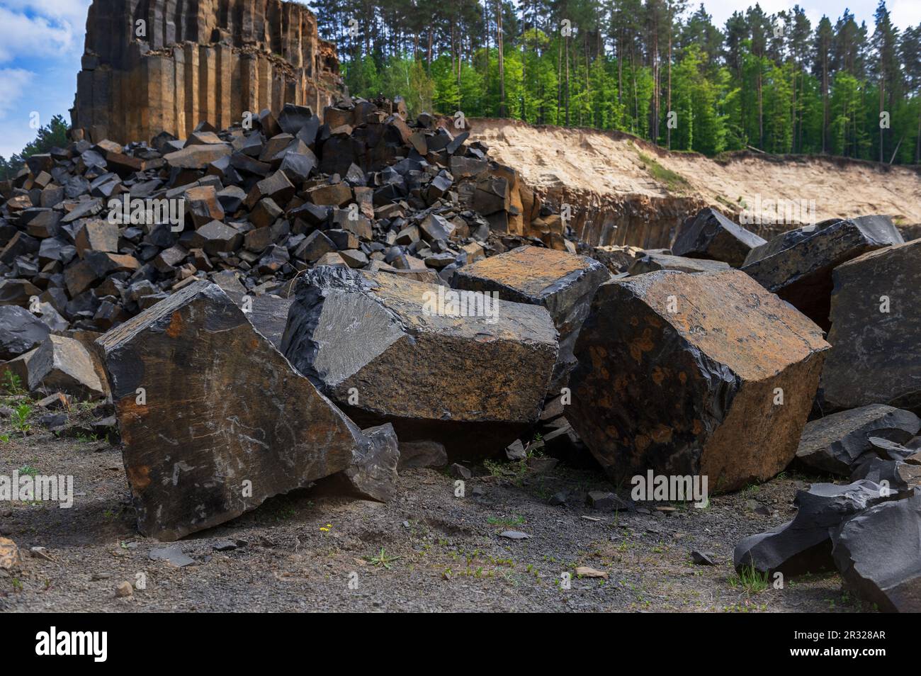 Basalt stones in a quarry. Columnar basalt quarry in summer. Volcanic ...