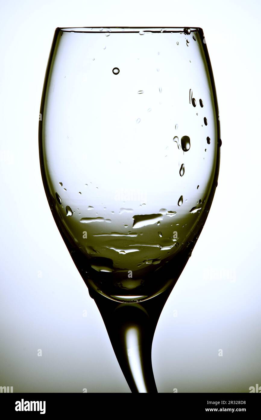 Curved wine glass with drops Stock Photo - Alamy