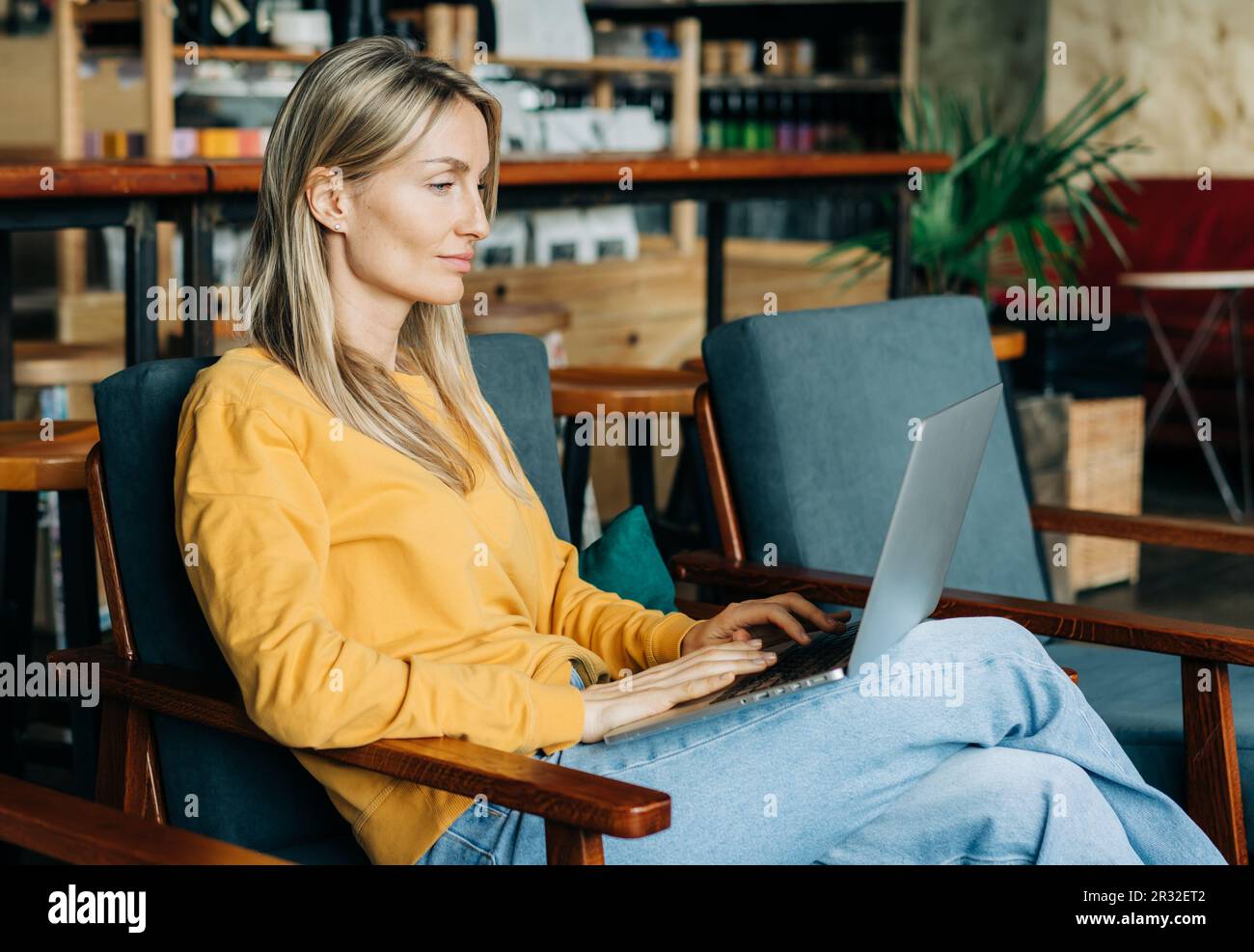 Focused Woman Browsing Laptop In Modern Cafe Stock Photo - Alamy