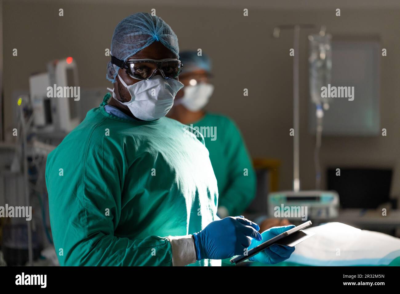 Portrait of african american male surgeon using tablet during surgery ...