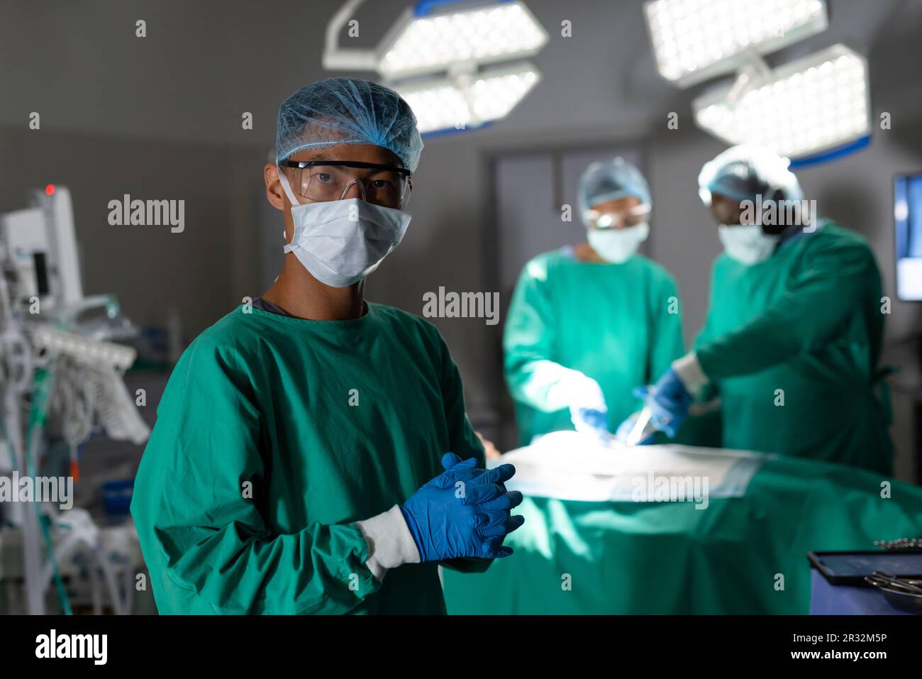 Portrait of asian male surgeon during surgery in operating theatre at ...