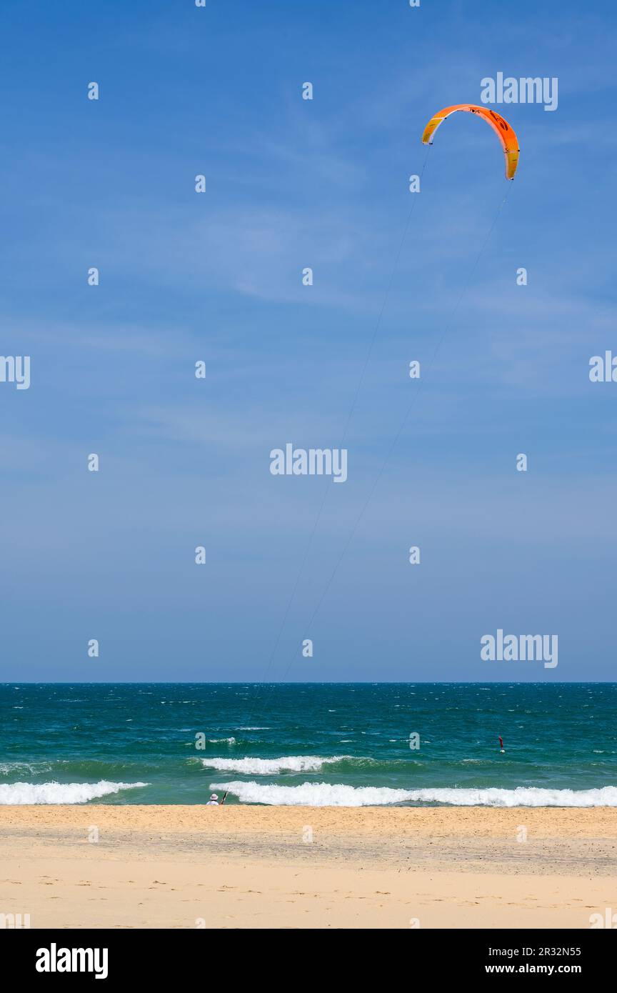 A male kitesurfer has launched his kite and is ready to depart from the ...