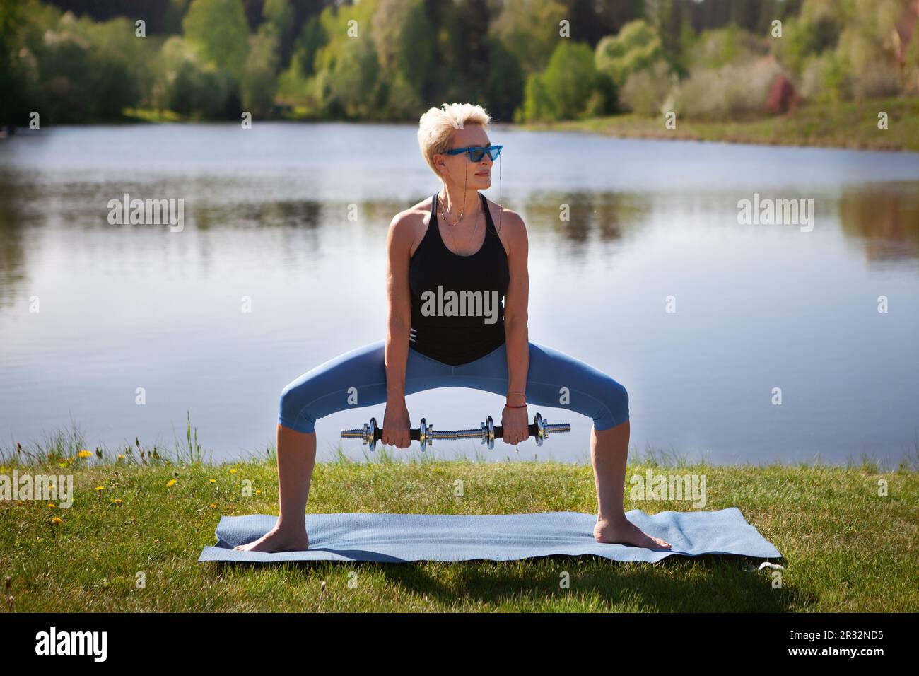 Middle aged woman enjoys workout, exercises, training body in midst of ...