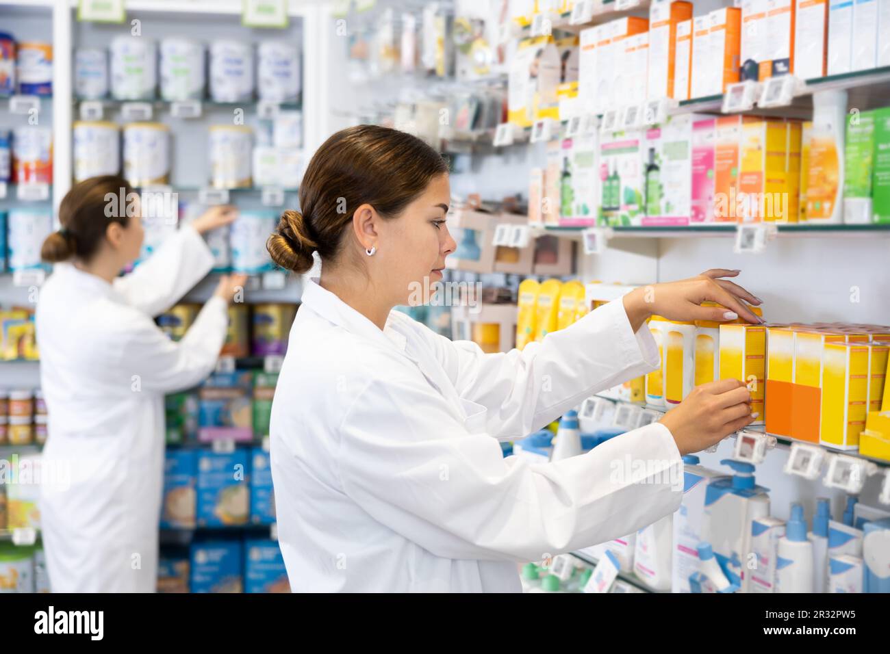 Pharmacy employee puts new healing body cosmetics on shelves Stock ...