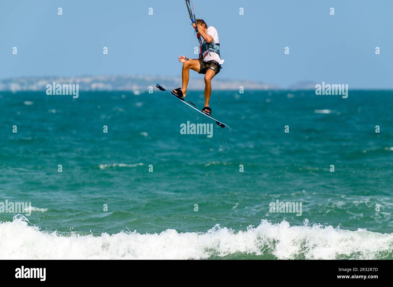A kitesurfer jumps high in the air off the beach in Mui Ne, Vietnam ...