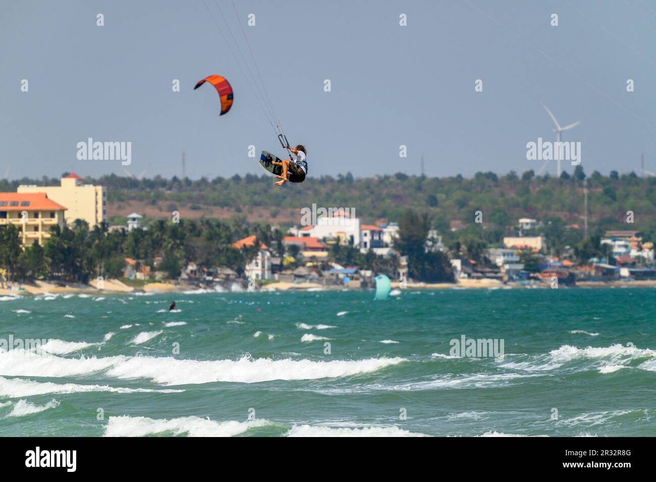A kitesurfer jumps high in the air with both feet come loose from the ...