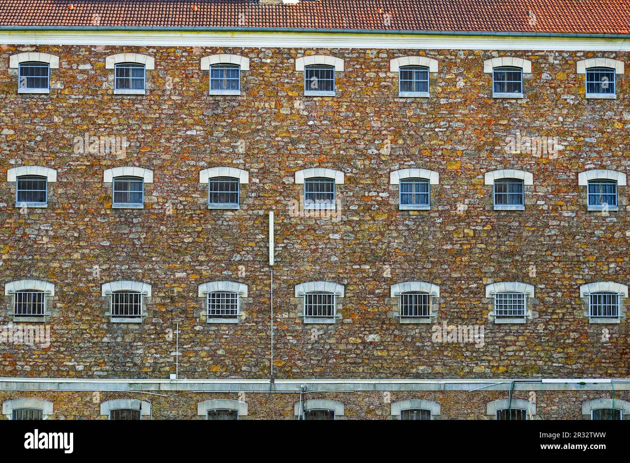 Cell windows aligned on the stone wall of the former prison of the city ...