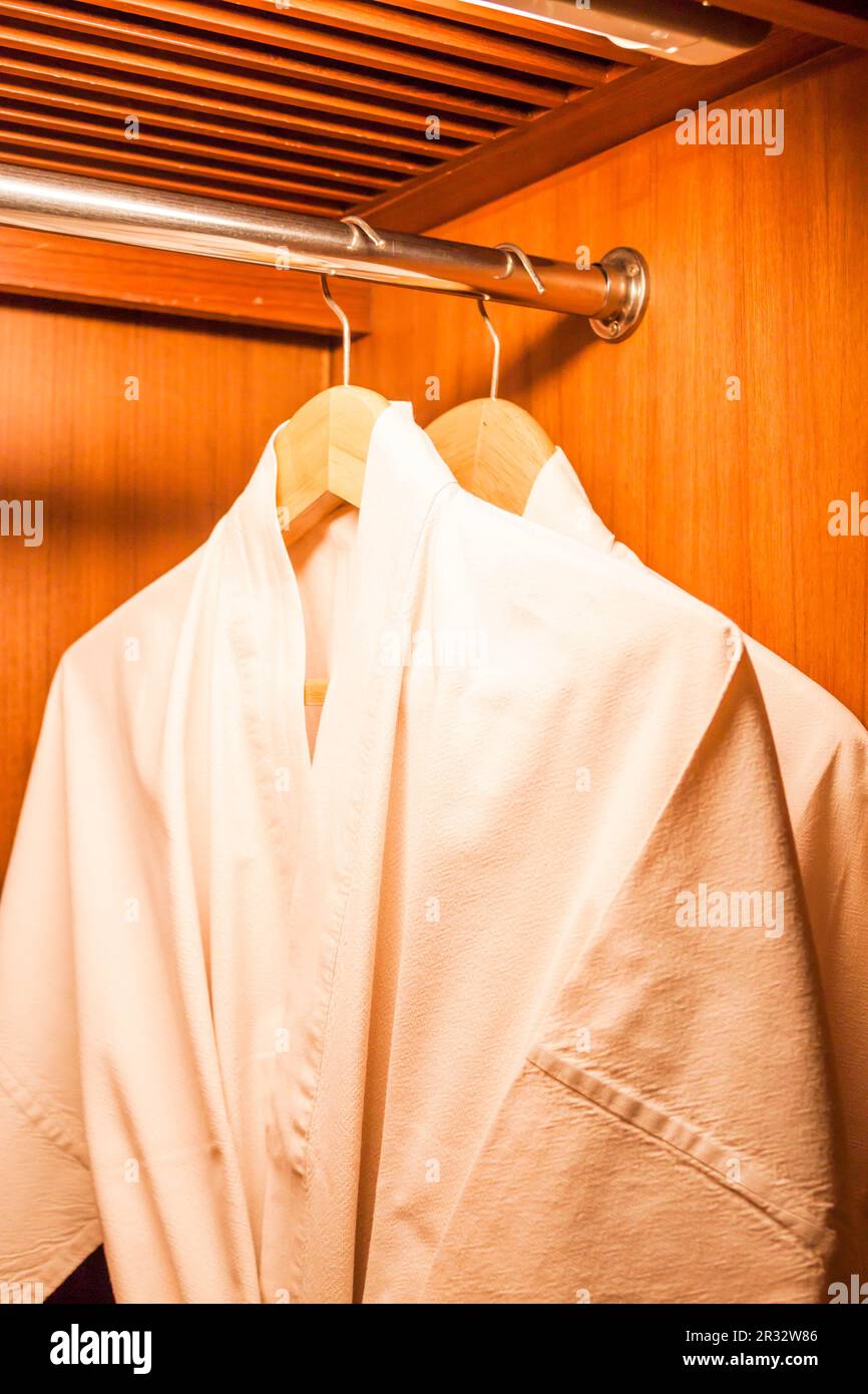 White robes with wooden hangers in hotel closet Stock Photo - Alamy