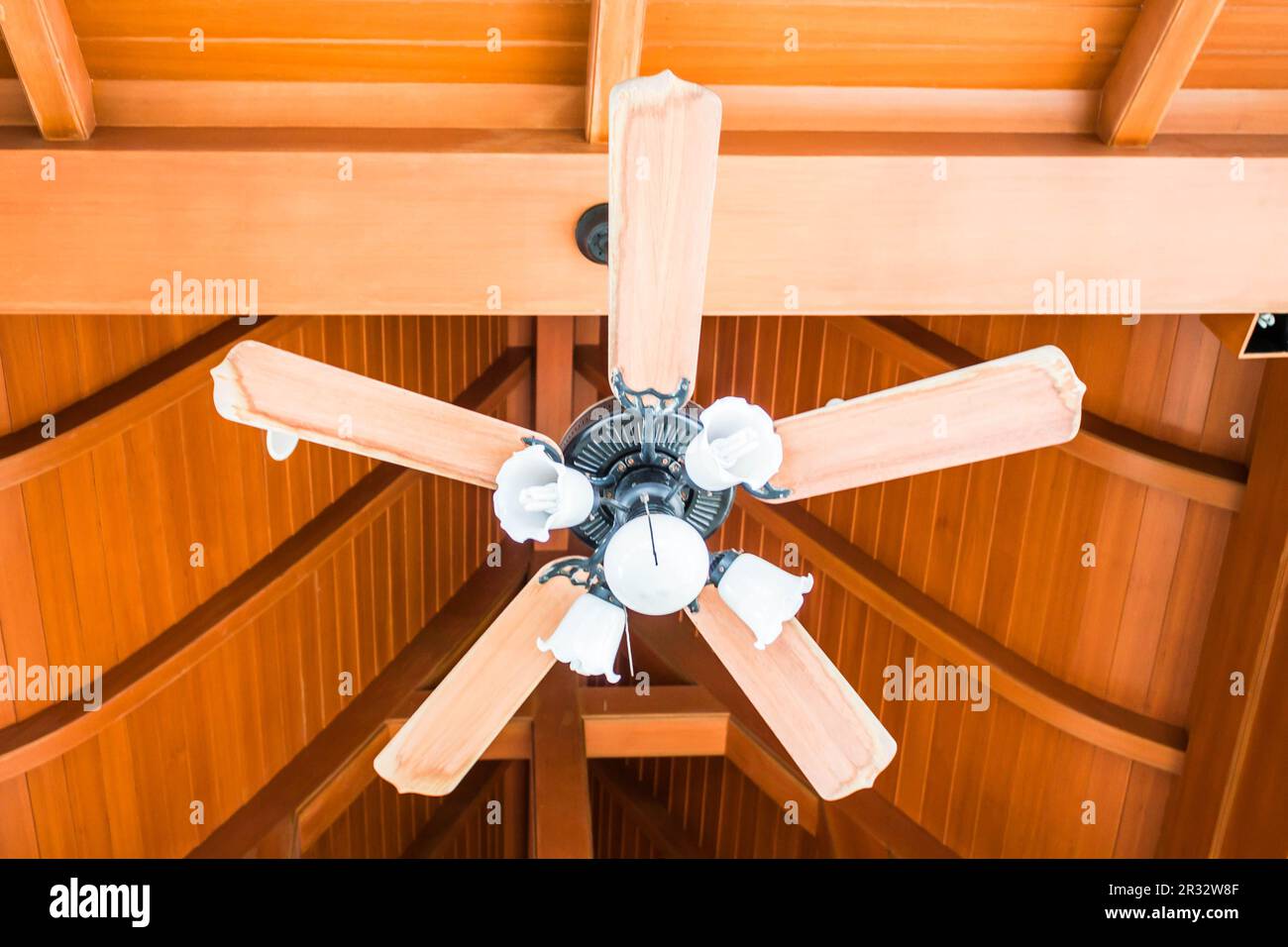 Classical wood ceiling fan with white glass lamps Stock Photo - Alamy