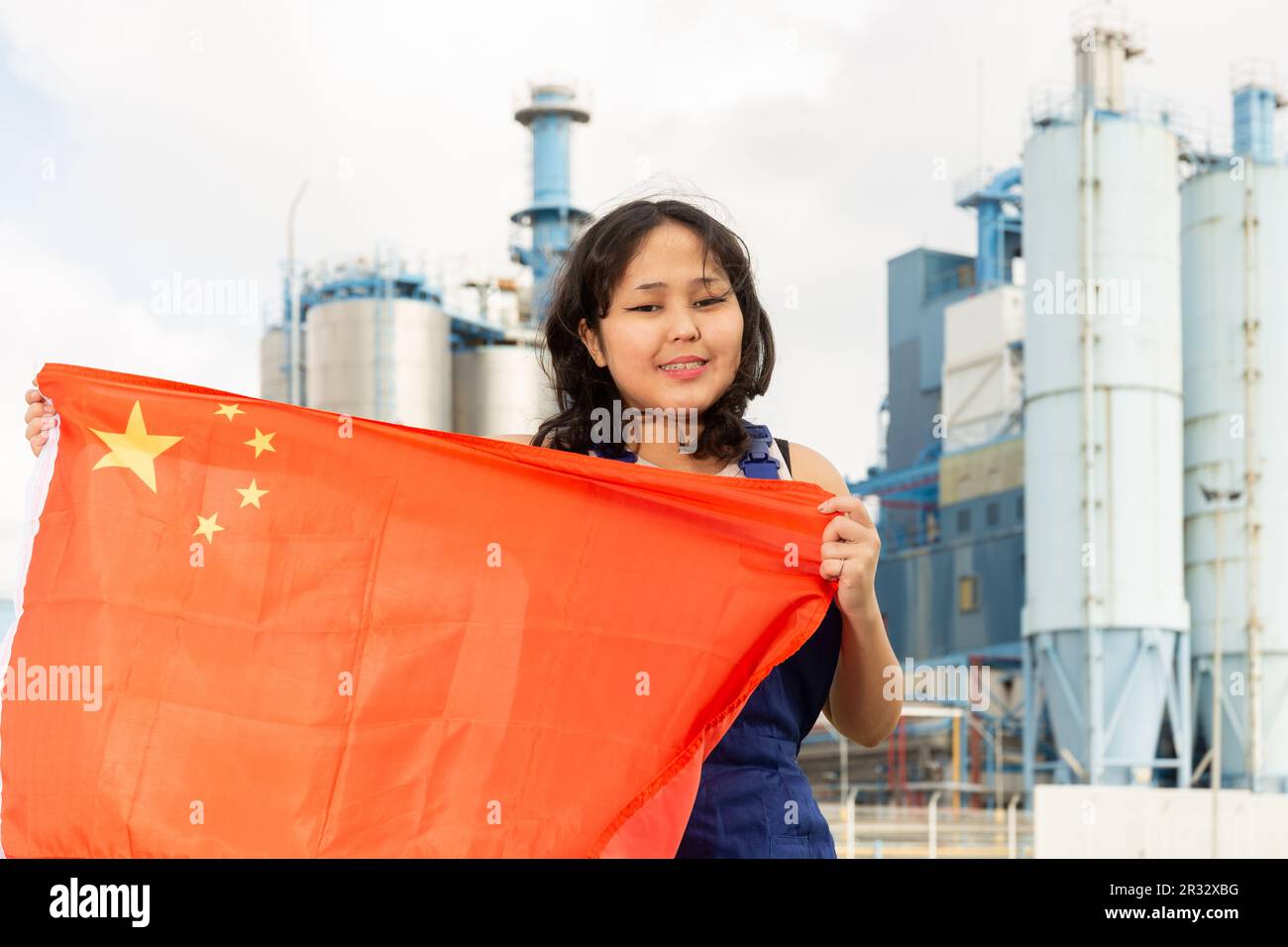 Happy asian girl in work clothes with flag of china standing in front ...