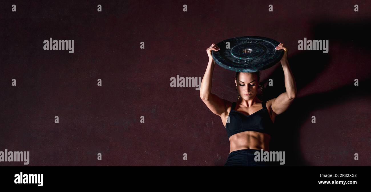 Young strong sweaty focused athlete muscular woman with muscles heavy ...