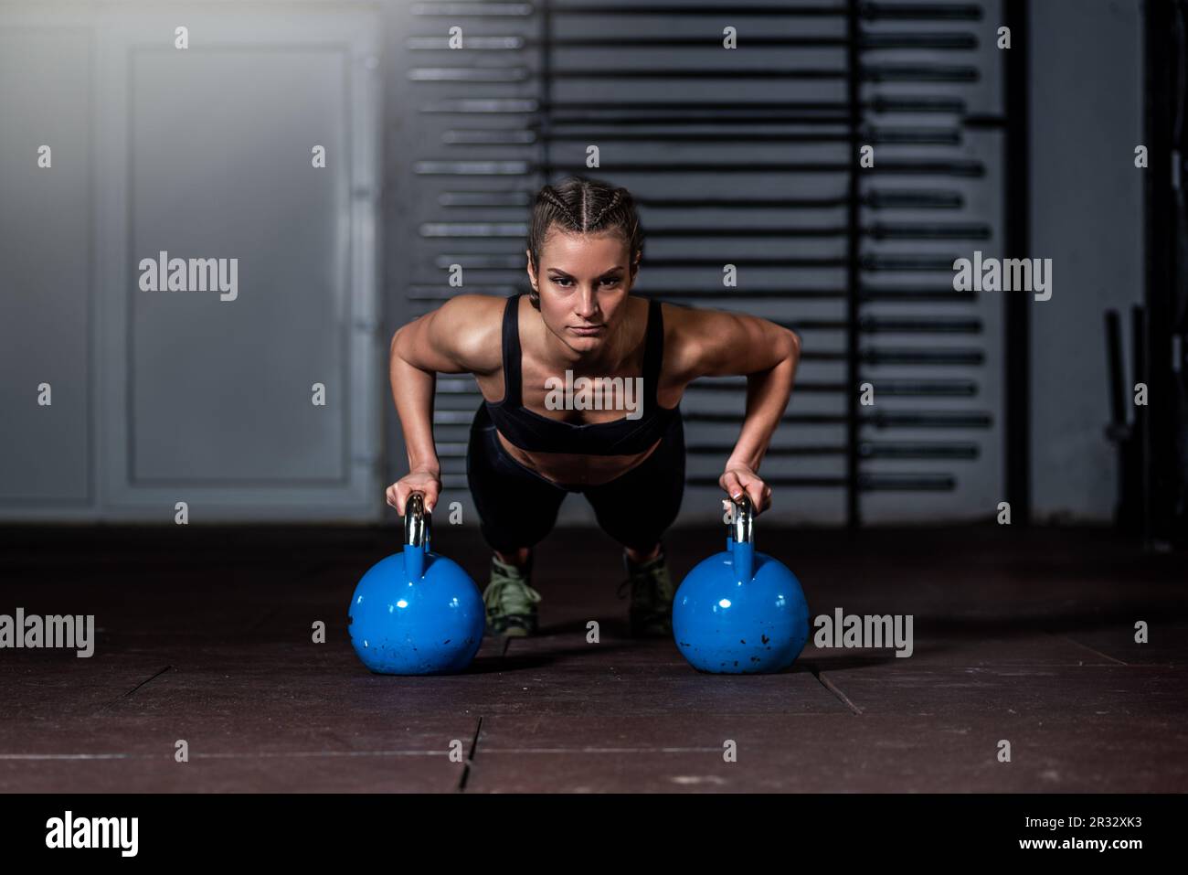 Young strong sweaty focused athlete muscular woman with muscles heavy ...