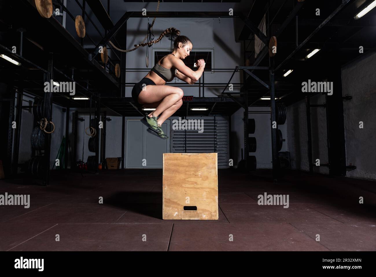 Young strong sweaty focused athlete muscular woman with muscles heavy kettlebell weight barbell ...