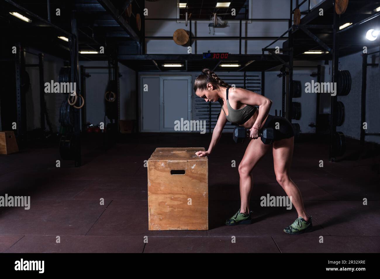 Young strong sweaty focused athlete muscular woman with muscles heavy kettlebell weight barbell ...