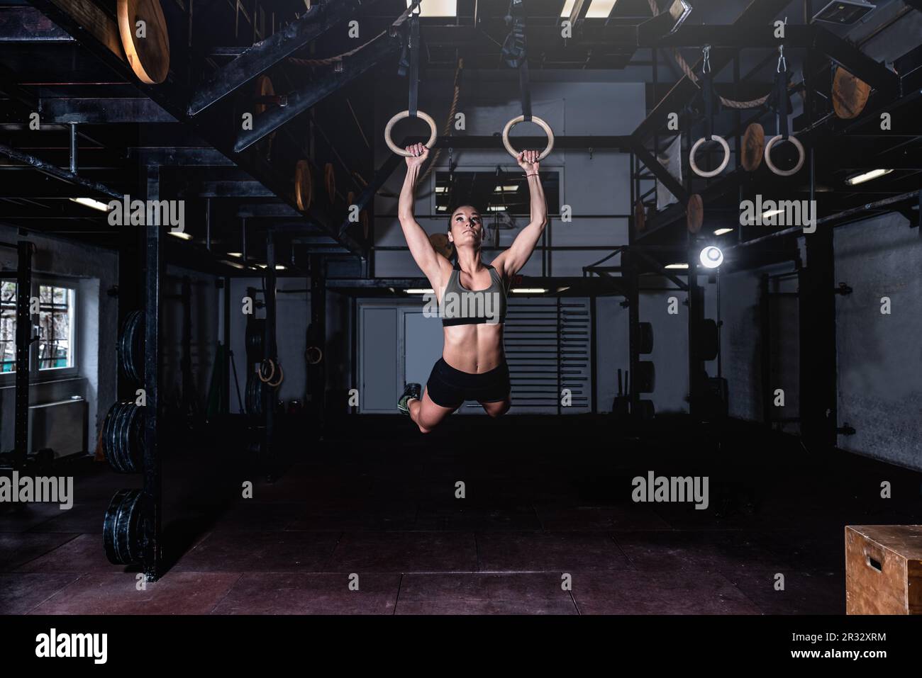 Young strong sweaty focused athlete muscular woman with muscles heavy kettlebell weight barbell ...