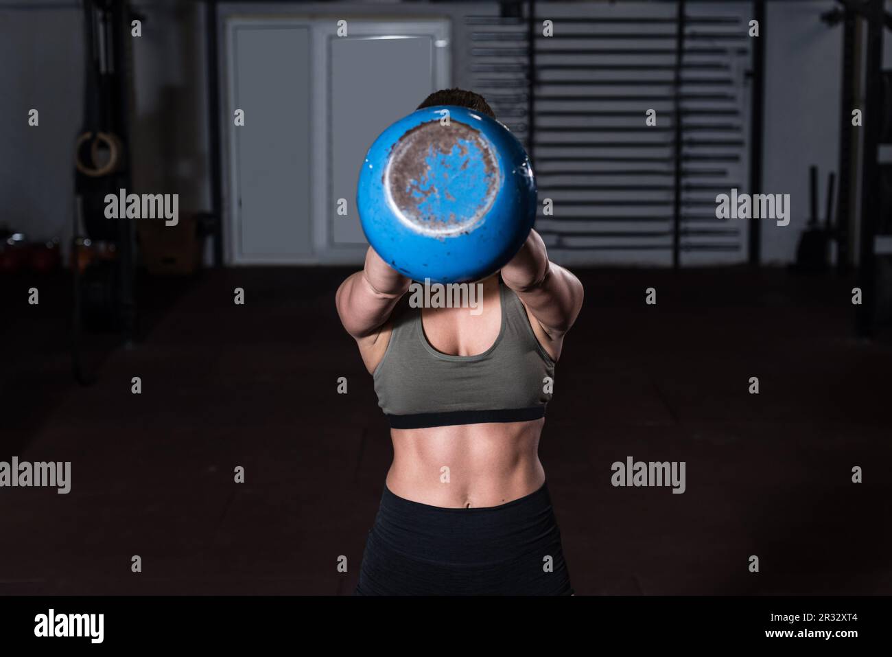 Young strong sweaty focused athlete muscular woman with muscles heavy ...