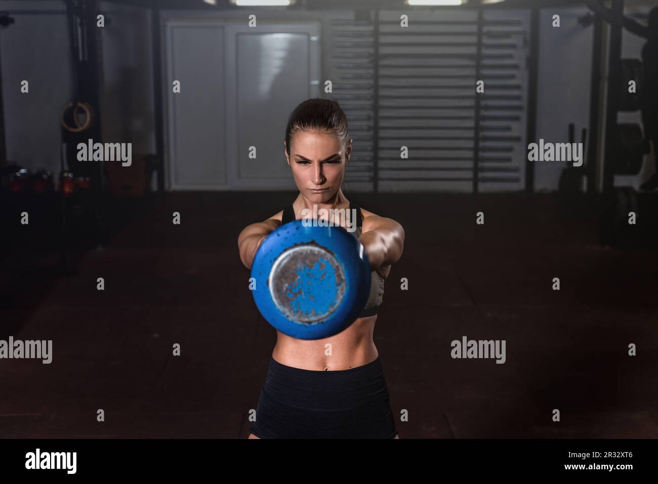 Young strong sweaty focused athlete muscular woman with muscles heavy ...