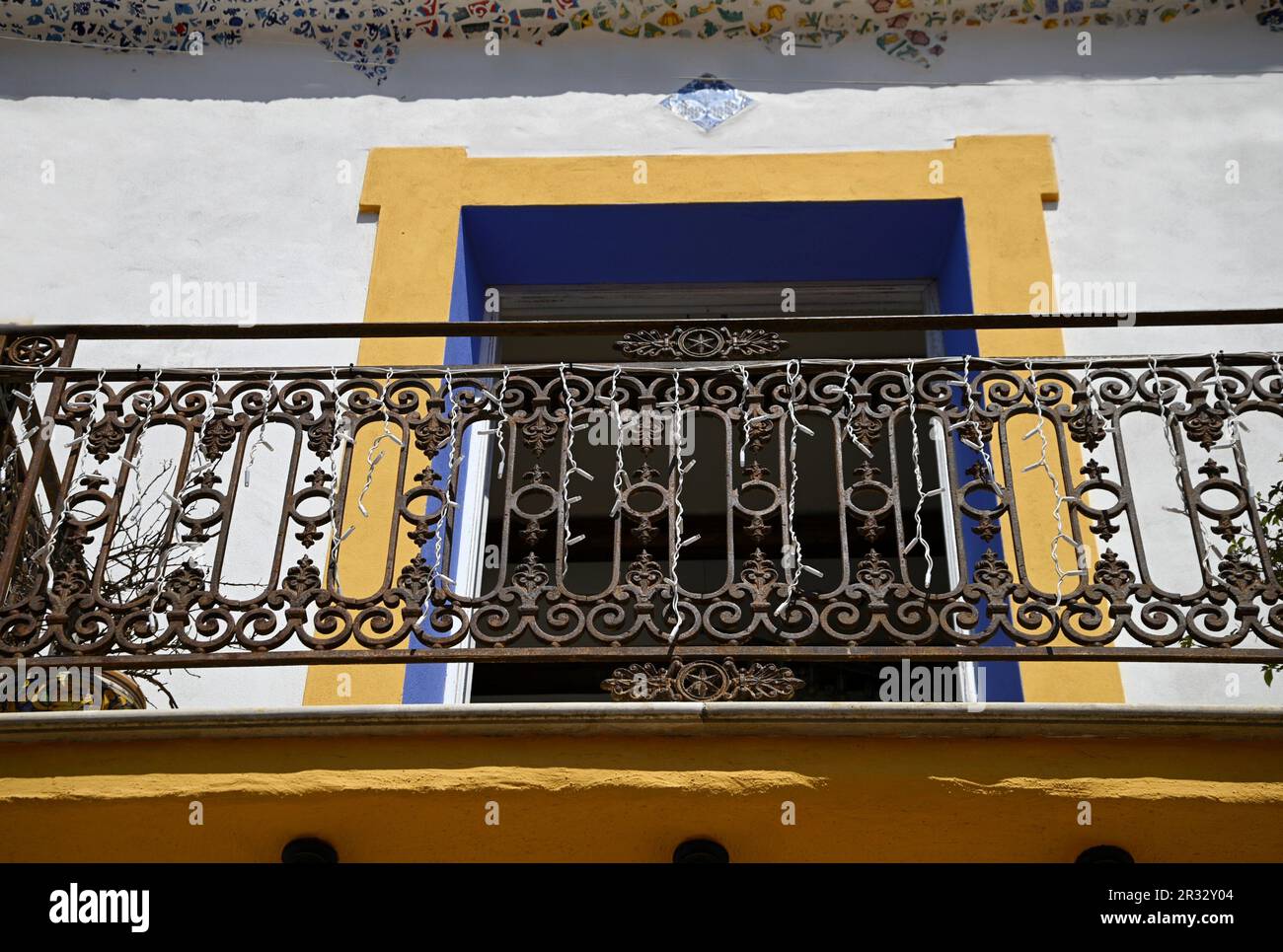 Art shop facade with a whitewashed wall, ochre trim, a handcrafted ...