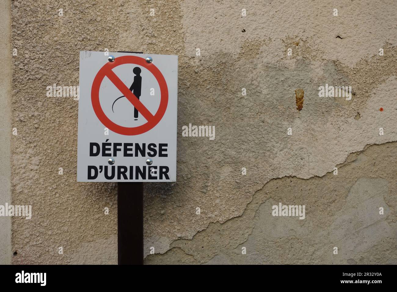 A please do not urinate sign in a small street in France ;French text ...