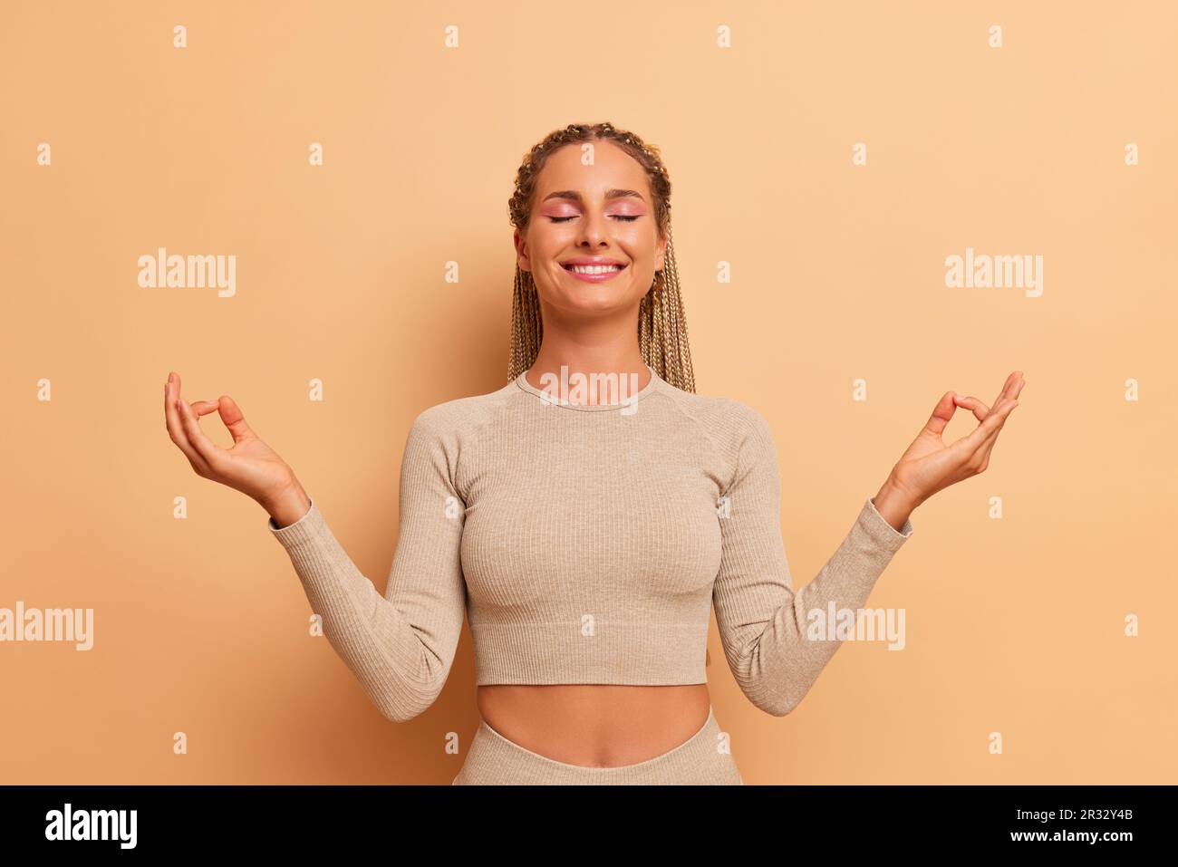 Slim girl with smile on her face stands against the background in the ...