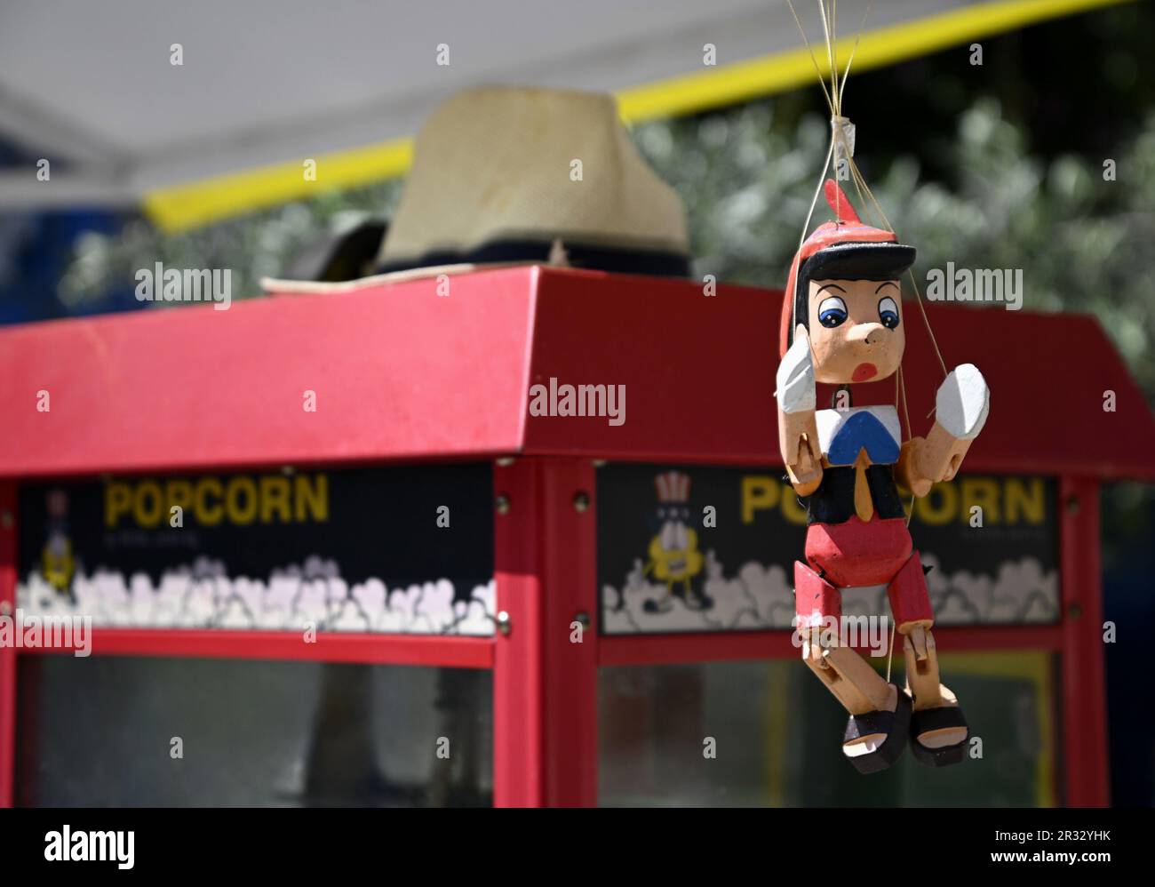 Pinocchio hanging on a retro pop corn cart on the main square of Borgo ...
