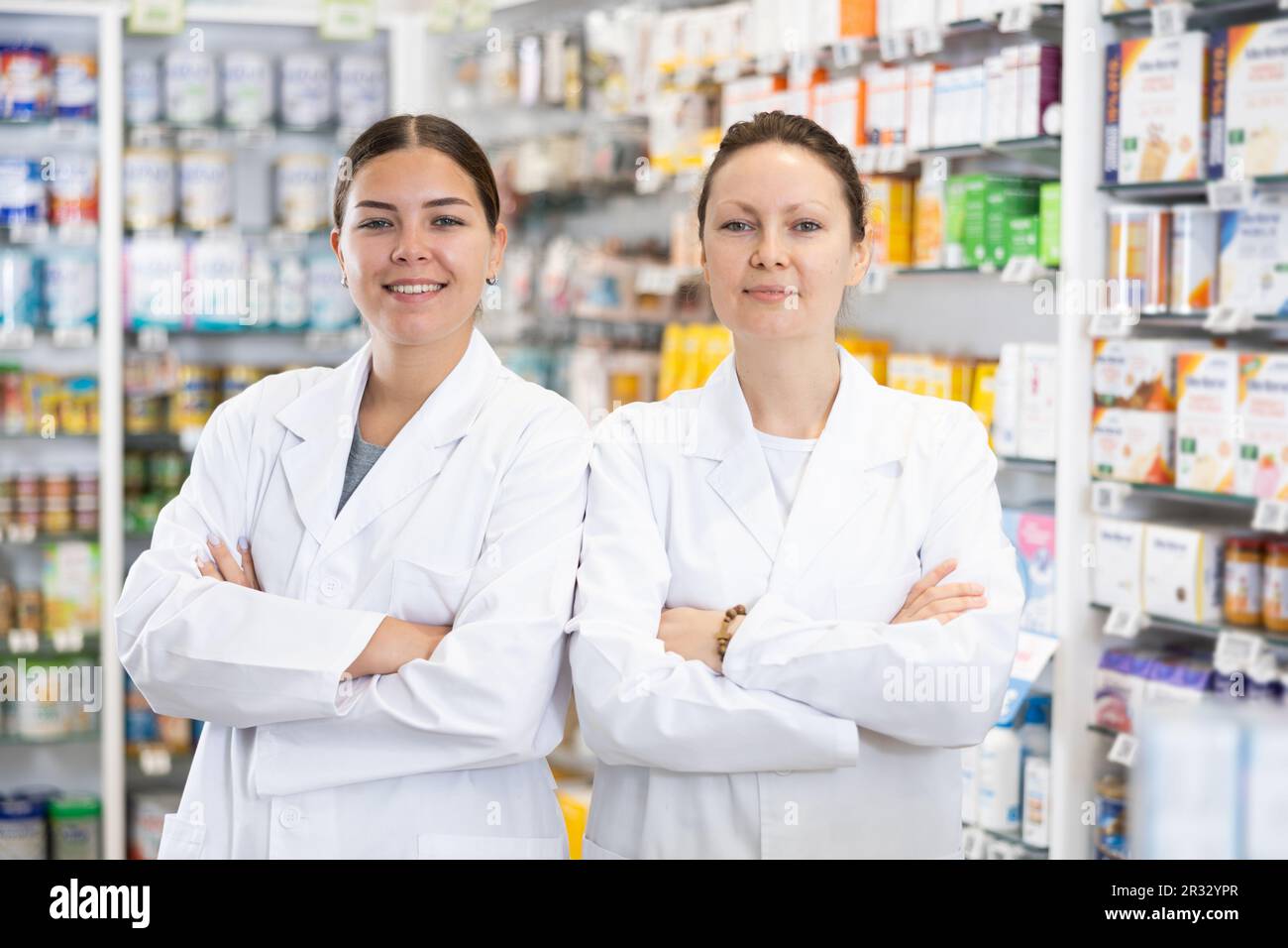 Portrait of two friendly positive pharmacists in interior of a pharmacy ...