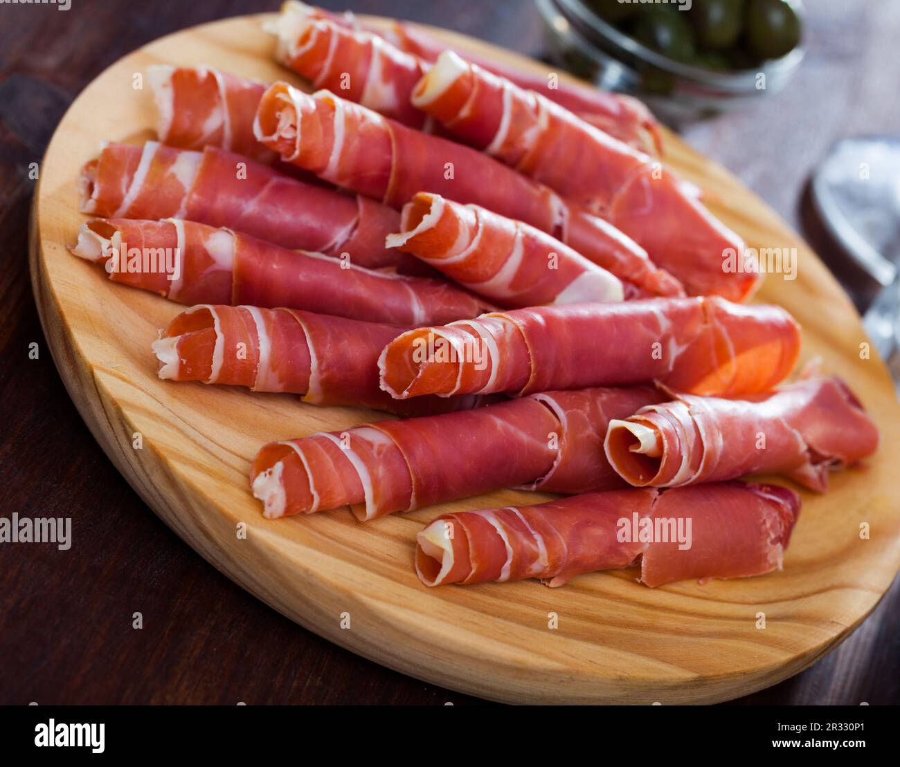 Spanish tasty meal rolls of prosciutto di parma at wooden desk Stock ...