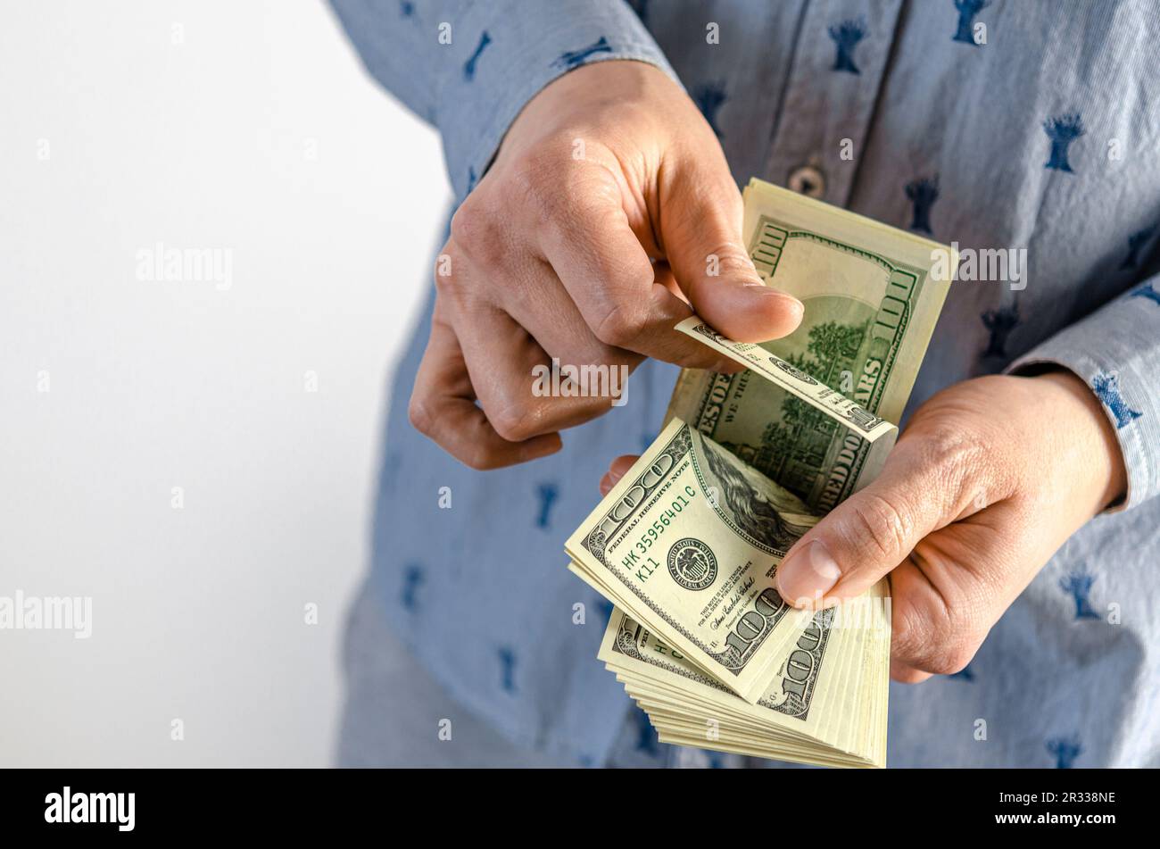A man hands over a thick wad of dollars. bribe Stock Photo - Alamy