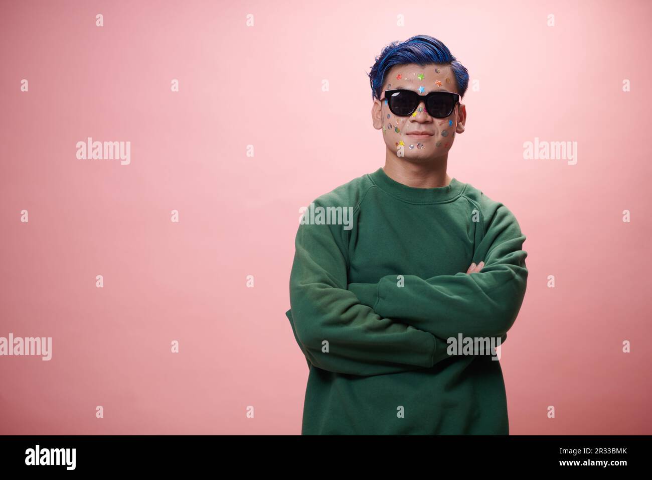 Stylish young man with stickers on face crossing arms Stock Photo - Alamy