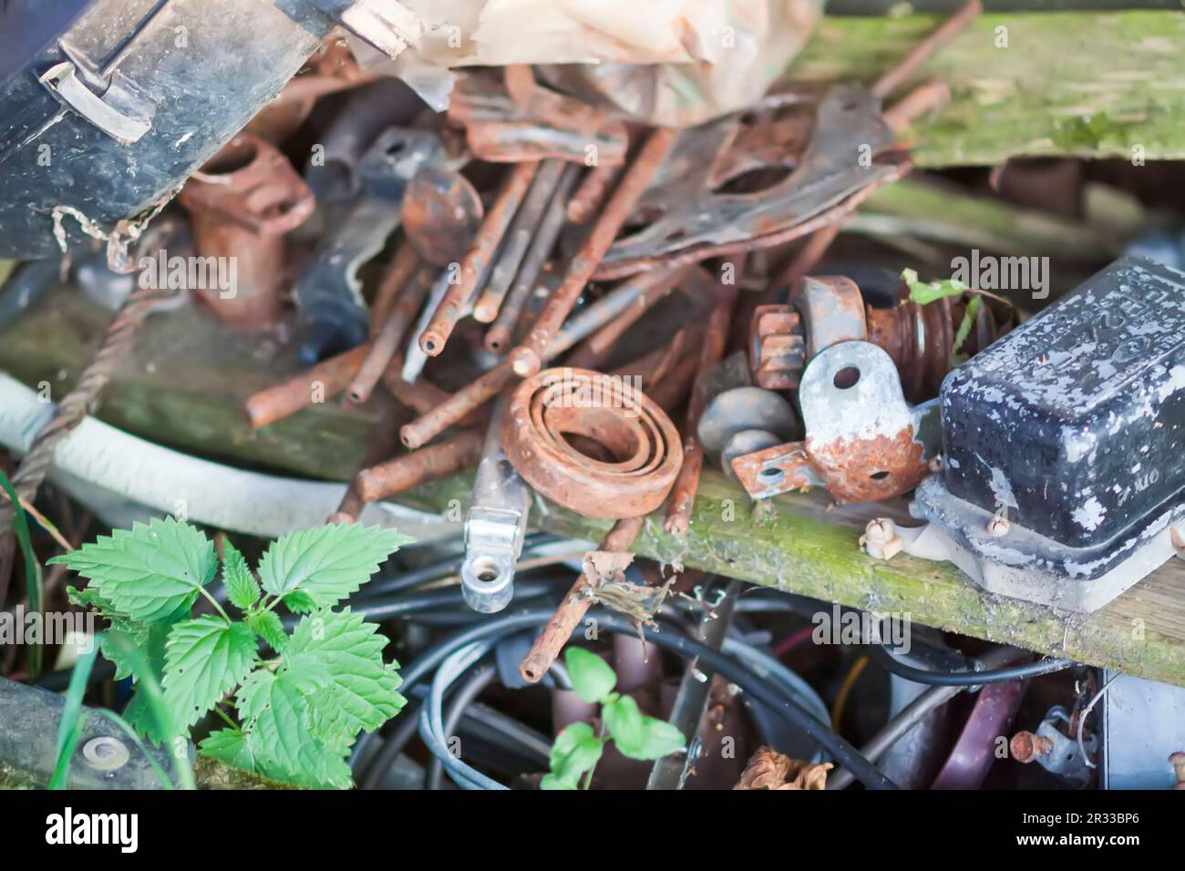 Scrap metal piled up on the old wooden table outdoors. Rusty objects ...
